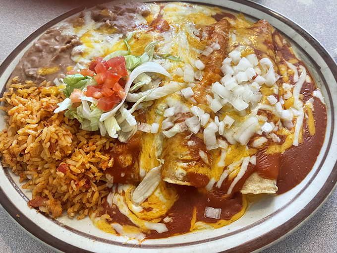 The holy trinity of New Mexican cuisine: red chile sauce, melted cheese, and rice that somehow absorbs all that flavor magic.