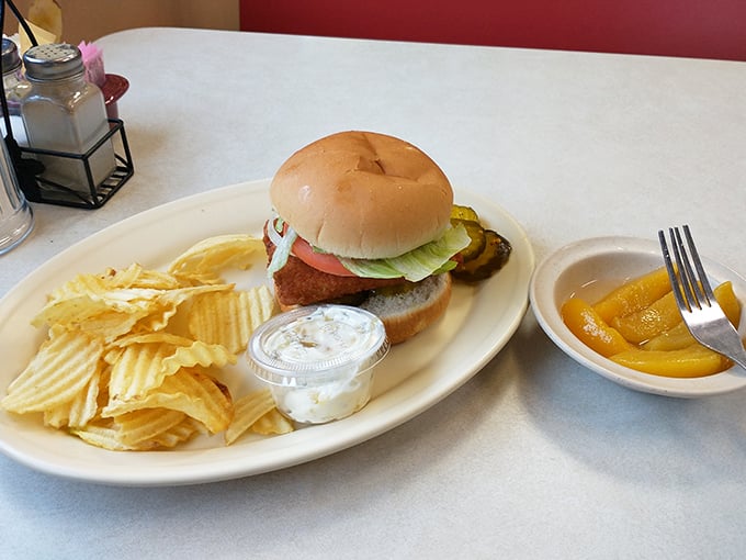 A classic diner sandwich with rippled chips and a side of peaches. Simple pleasures that remind you why diners have endured for generations.