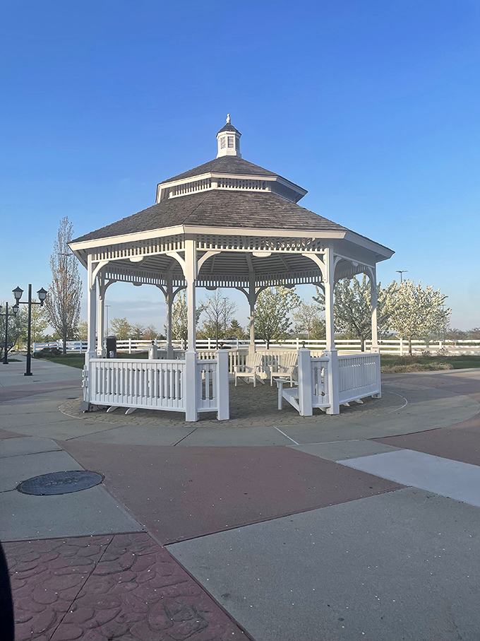This pristine white gazebo isn't just for show &ndash; it's where relationships survive the "just one more store" negotiations that define outlet shopping.