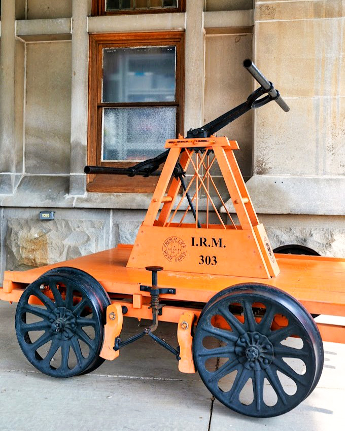 This bright orange hand car, once used by railway workers for track inspection, now stands as a charming reminder of railroading's labor-intensive past.