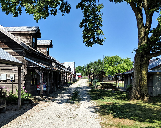 Rustic wooden storefronts create a shaded walkway that feels like stepping into a sepia photograph. This isn't manufactured charm&mdash;it's the real, weathered thing.