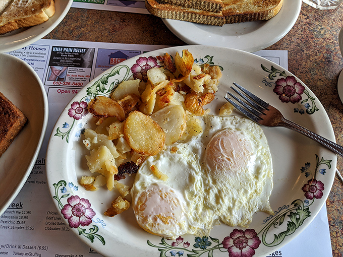 The holy trinity of breakfast perfection: golden home fries with crispy edges, eggs cooked just right, and a plate that doesn't need Instagram filters to look good.