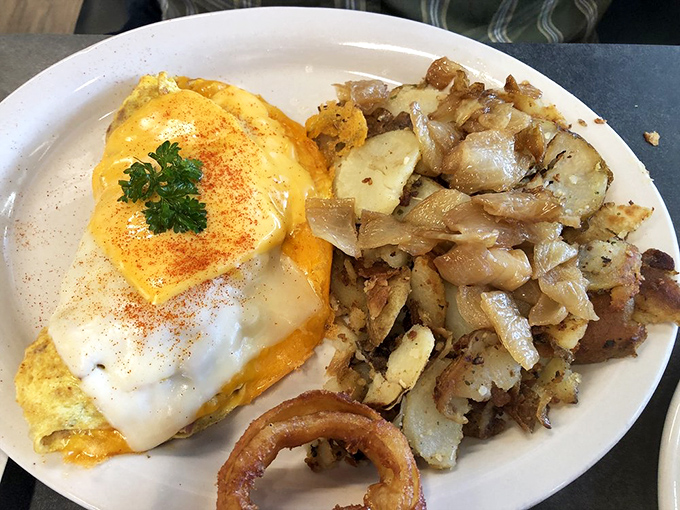 Breakfast nirvana achieved: perfectly seasoned home fries alongside an egg-topped creation that makes Monday mornings bearable again.