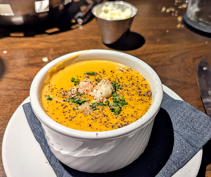 A velvety lobster bisque that whispers of the sea, garnished with delicate seafood morsels and fresh herbs &ndash; comfort in a bowl.