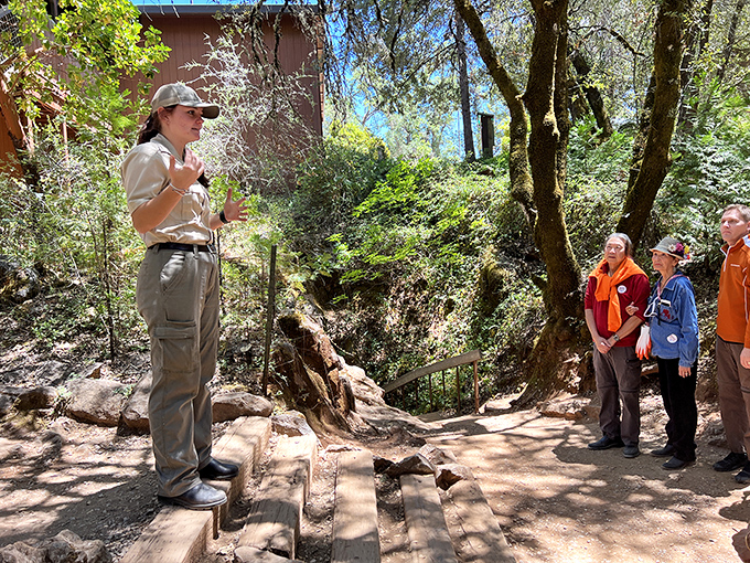Knowledge makes the experience! A guide shares fascinating cave facts with visitors before they descend into the cool, mysterious world below.