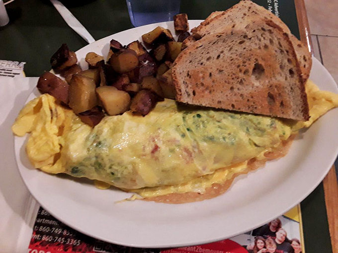 This isn't just any omelet&mdash;it's a fluffy yellow canvas painted with vibrant vegetables and melted cheese, served with home fries that could convert a carb-avoider.