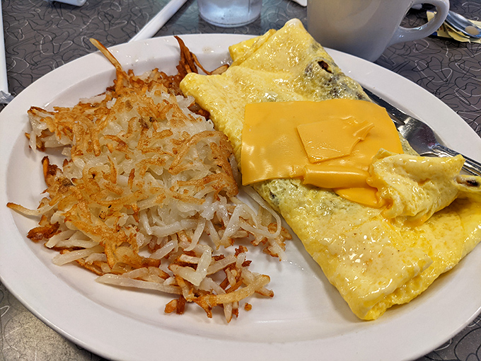 The breakfast of champions isn't cereal—it's a perfectly executed omelet with crispy hash browns that shatter like dreams when your fork hits them.