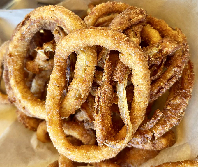 These onion rings aren't just fried—they're golden halos of crunch that make you wonder why vegetables ever bothered growing any other way.