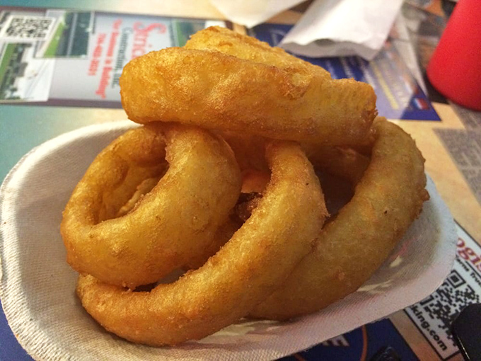 Golden-fried onion rings that shatter with each bite, proving that sometimes the simplest pleasures are the most profound.