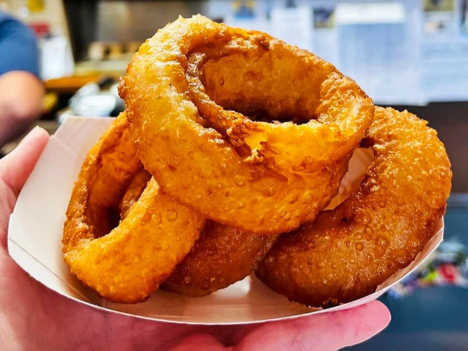Golden-brown onion rings that crunch like autumn leaves, revealing a tender interior that makes you wonder why anyone bothers with complicated appetizers.