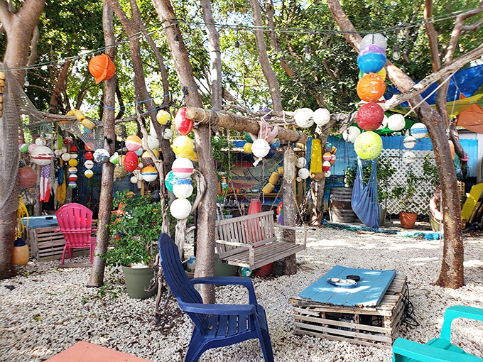A whimsical outdoor lounge where colorful buoys dangle from trees like tropical fruit. The perfect spot to embrace the Keys' "why not?" philosophy.