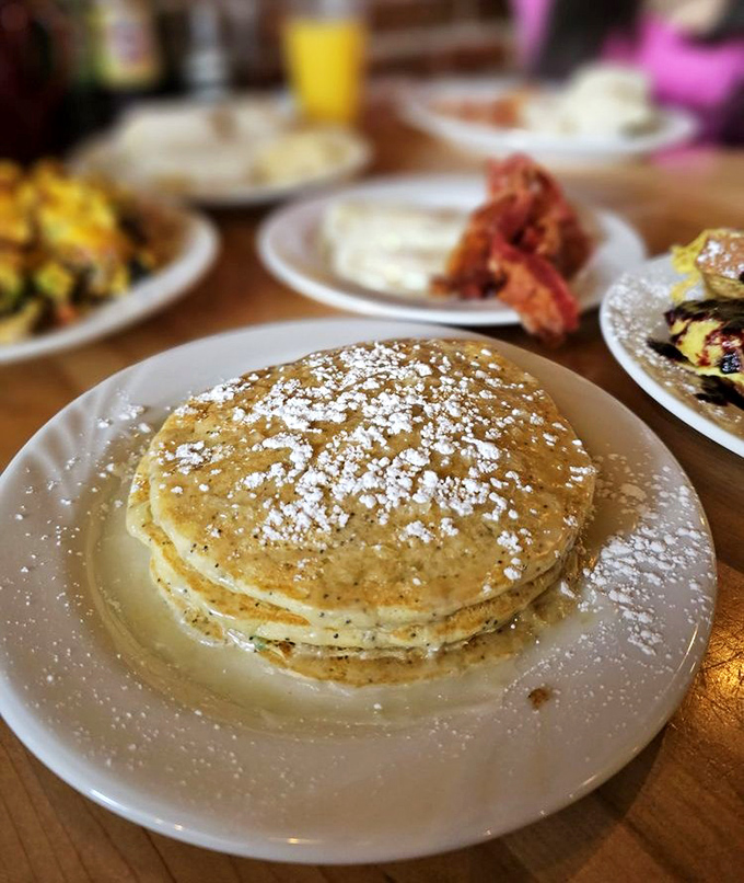Stack of pancakes that whispers "good morning" in the gentlest way possible, with a light dusting of powdered sugar like fresh Idaho snow.