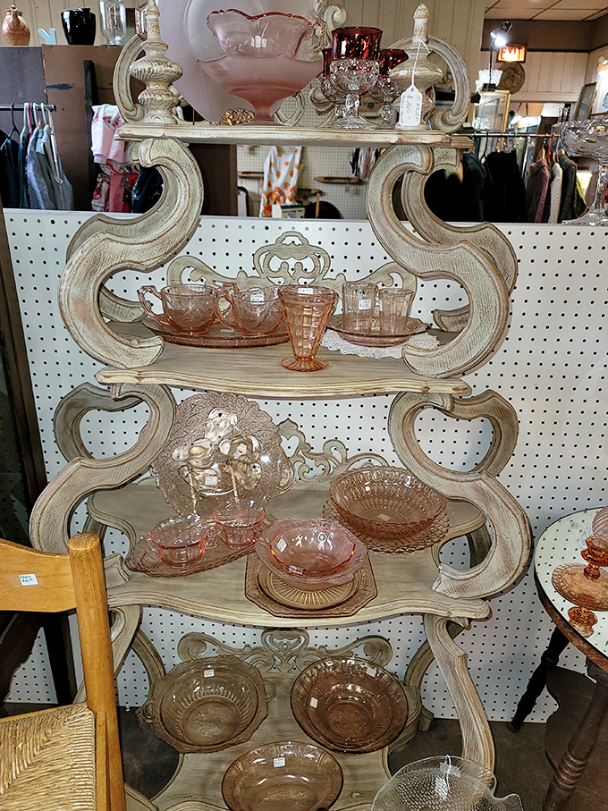 This ornate wooden shelf cradles pink Depression glass like a museum display, each delicate piece surviving cocktail parties and Sunday dinners of yesteryear.