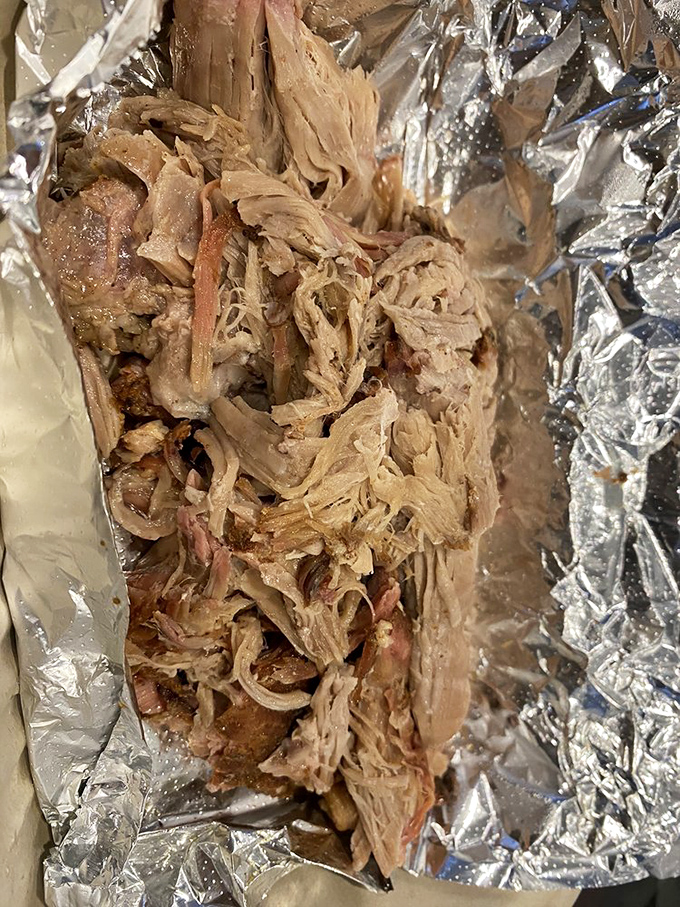 Pulled pork so tender it practically surrenders at the sight of your fork, nestled in foil like the precious treasure it truly is.