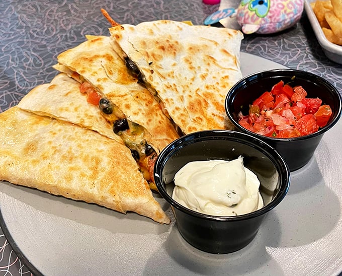Quesadillas served with the holy trinity of Tex-Mex condiments &ndash; sour cream, salsa, and a story you'll tell friends about finding authentic flavor in unexpected places.