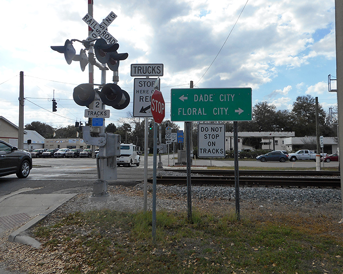 Small-town navigation at its finest&mdash;where railroad crossings and directional signs remind you that life's intersections are best approached at a leisurely pace.