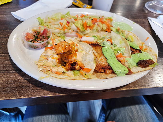 A trio of tacos featuring both land and sea, proving that variety isn't just the spice of life&mdash;it's the main course.