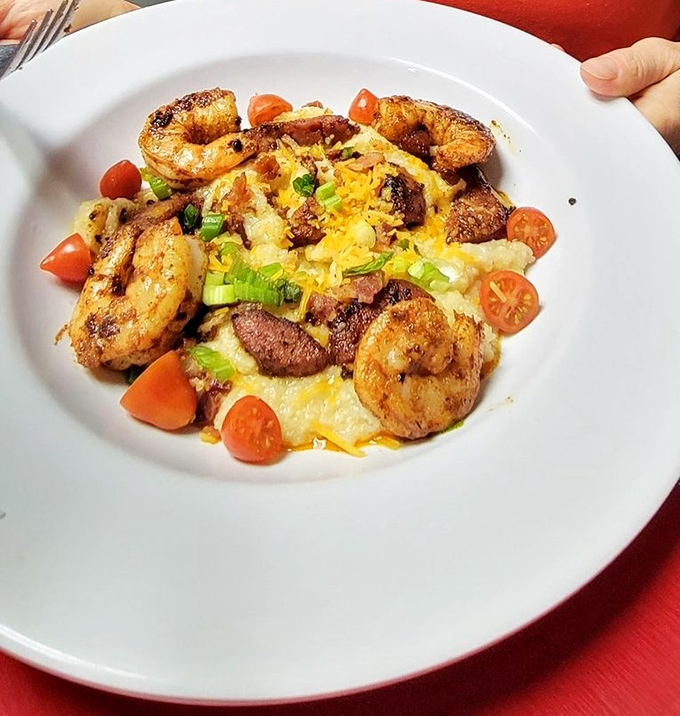Shrimp and grits elevated to an art form&mdash;plump Gulf shrimp surrounding a creamy island of cheesy goodness, brightened with fresh tomatoes.