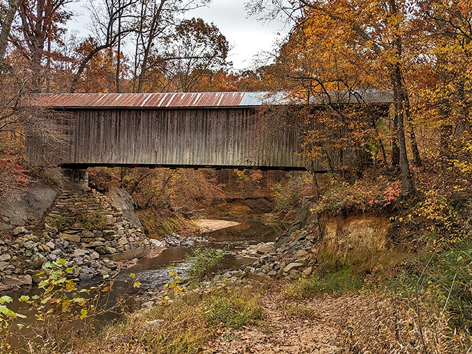 From this angle, you can almost hear the creek whispering stories beneath the weathered planks that have witnessed centuries of footsteps.