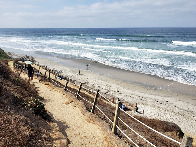 The switchback trail leads adventurers down to surfer's paradise. That wooden fence isn't keeping anyone from their date with perfect waves.