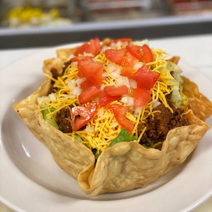 The taco salad arrives in its edible fortress, a crispy shell protecting the savory treasures within like a delicious moat.