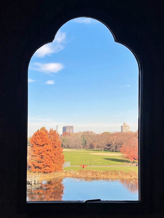 Window to another world. The castle's Gothic-arched windows frame breathtaking views of autumn foliage and the Great Lawn beyond.