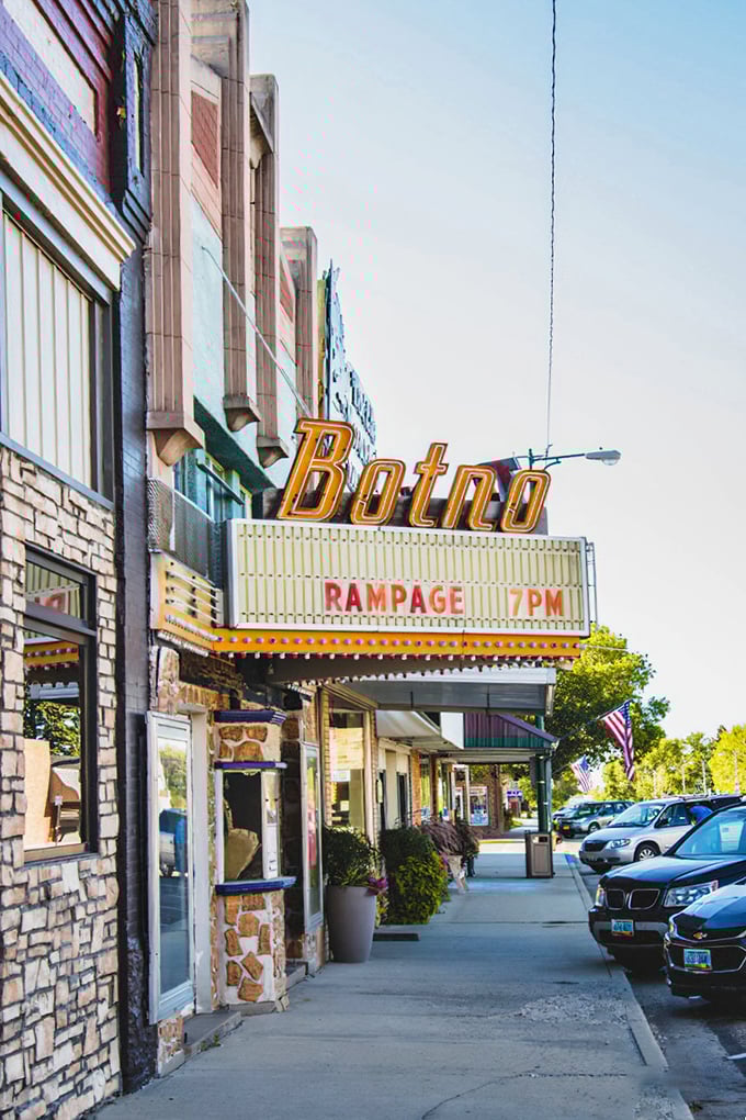 The Botno theater's vintage marquee sparkles like a ruby jewel, promising entertainment that tastes sweeter than movie candy.