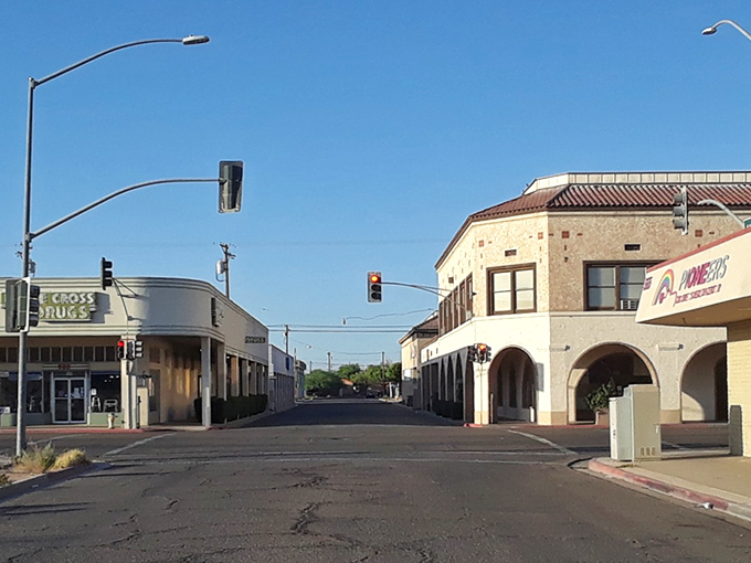 Brawley's empty intersection bakes under desert sun, where Cross Drugs and arched porticos offer shade like oases in this Imperial Valley outpost.