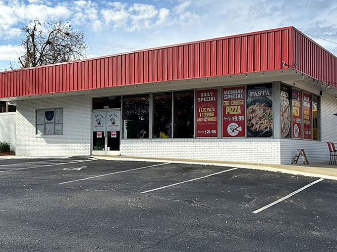 That red metal roof signals comfort food territory where generous portions meet old-fashioned pizza making traditions.