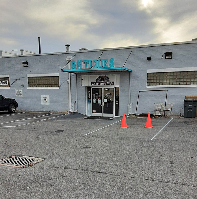 Charlotte's Web Antique Mall's turquoise sign pops against the white building &ndash; a colorful hint at the treasures within.