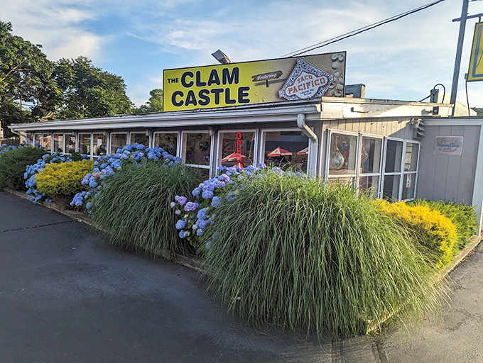 The Clam Castle's vibrant flowers say "welcome" while the yellow sign practically shouts "get your seafood here!"