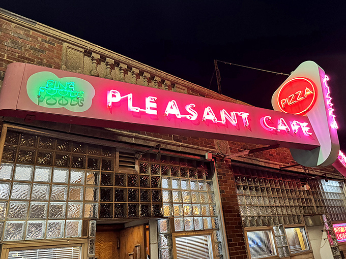 Pleasant Cafe's neon glow beckons like a beacon for those seeking authentic pizza in Roslindale's heart.