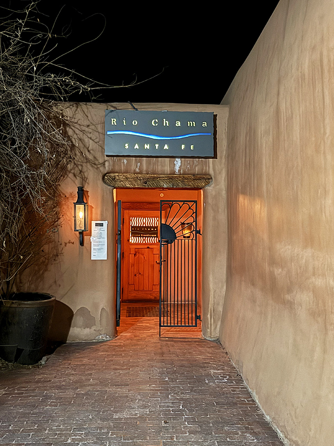 Rio Chama's entrance glows with warm invitation, like a portal to flavor paradise. That wrought-iron gate guards delicious secrets.