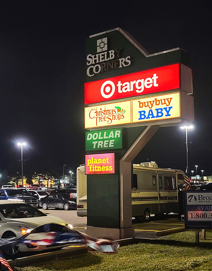 Shelby Corners' towering sign stands sentinel in the night, a beacon of retail therapy for weary shoppers seeking after-hours deals.