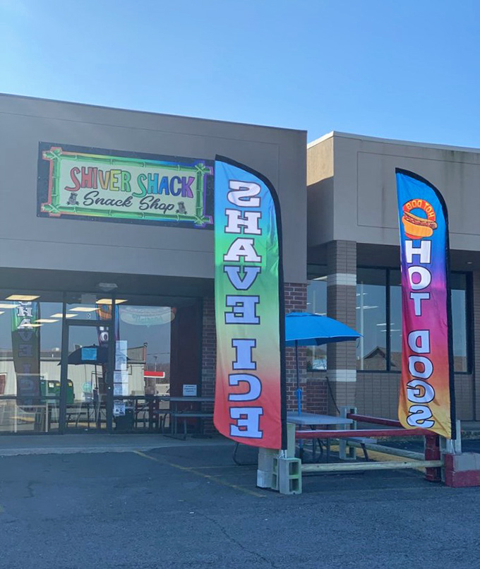 Shiver Shack waves its flags high - "HOT DOGS" and "SHAVE ICE" spelling out the perfect combo.