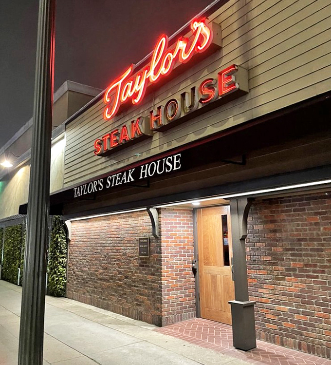That glowing red neon cuts through the night like a lighthouse for hungry steak lovers.