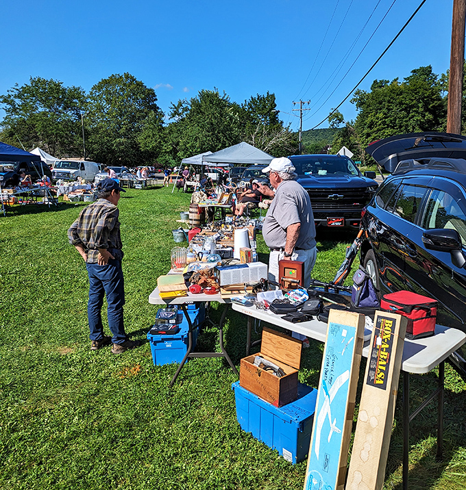 Shoppers browse leisurely where grass meets gravel—this isn't rushed mall shopping, it's treasure hunting with fresh air included.