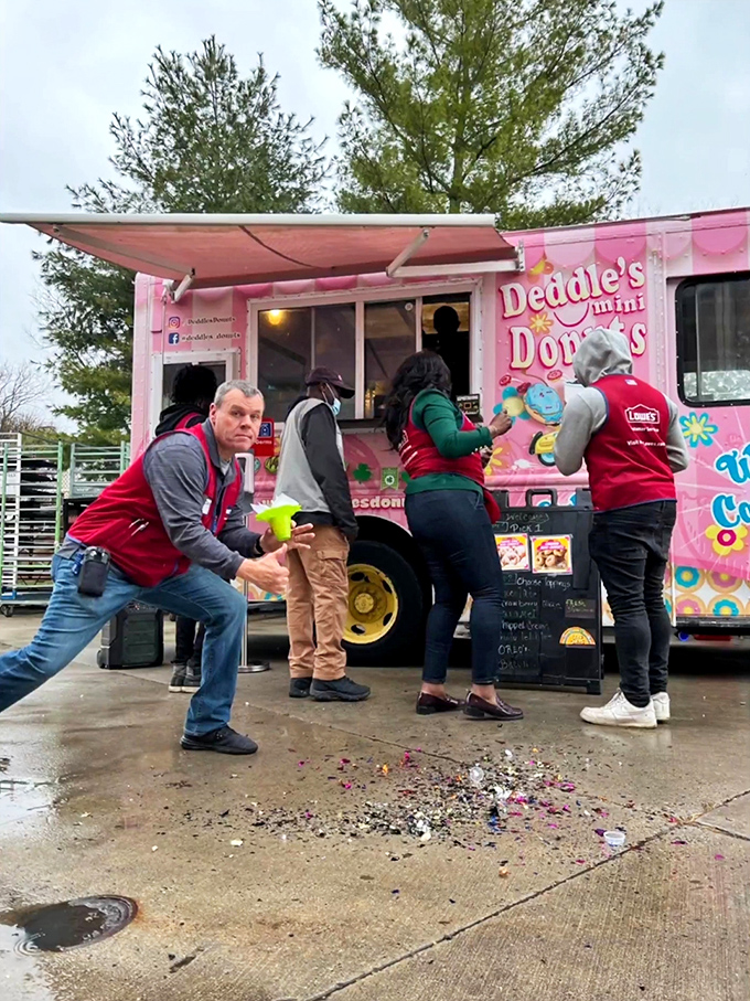 The crowd gathering around this pink donut paradise proves that fresh mini donuts can create spontaneous community wherever they're served.