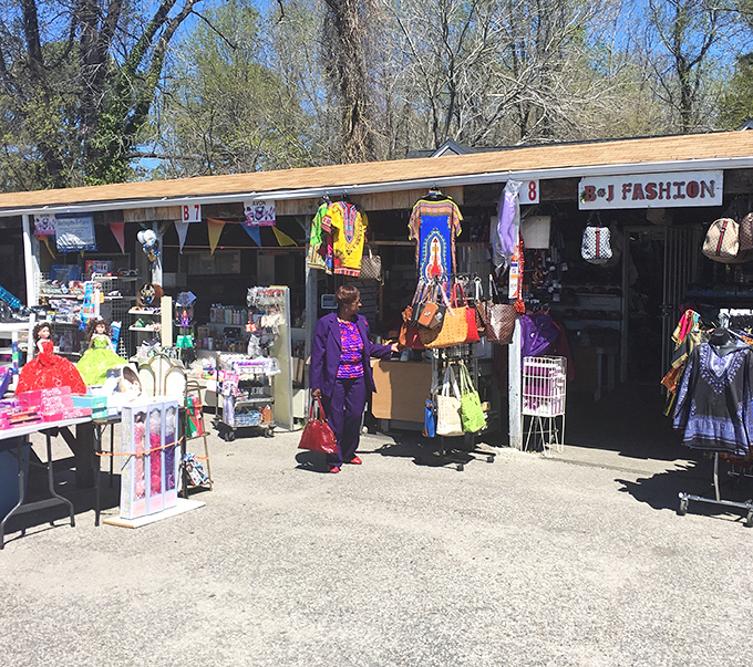 Colorful clothing displays catch the eye while vendors arrange their wares for maximum browsing appeal.
