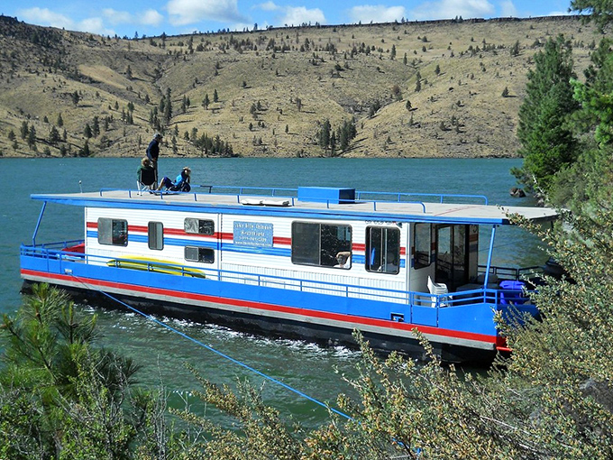 A colorful houseboat glides across blue waters near Prineville. Who needs a cruise ship when retirement offers this?
