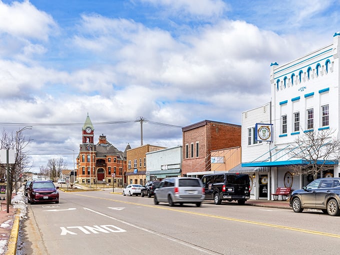 A charming view of downtown along the storefronts, featuring historic buildings, a clock tower, and a peaceful, sunny day.
