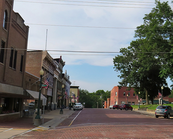 Mount Carroll's brick buildings climb the hillside, their warm tones glowing in the afternoon sun against a backdrop of trees.