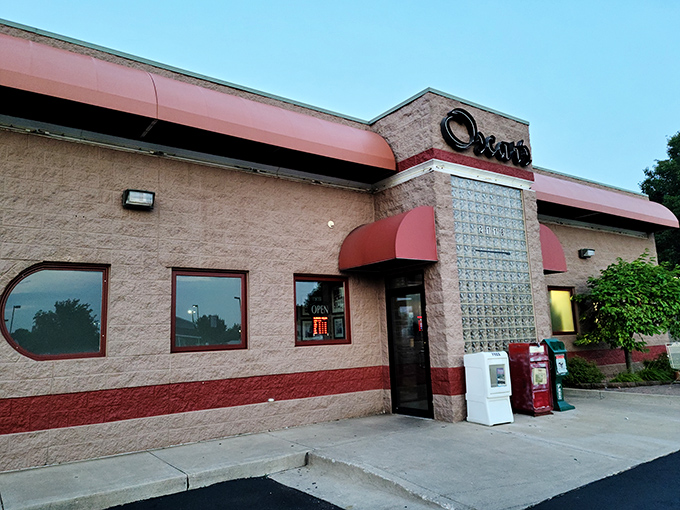 When evening falls, that glass block entrance glows like a lighthouse guiding hungry souls to burger paradise.