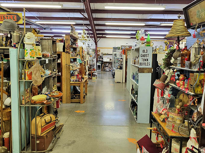 Treasures' aisles stretch toward infinity, creating canyons of collectibles. The sign promising "Old Ghost Town Bottles" hints at the stories waiting around every corner.