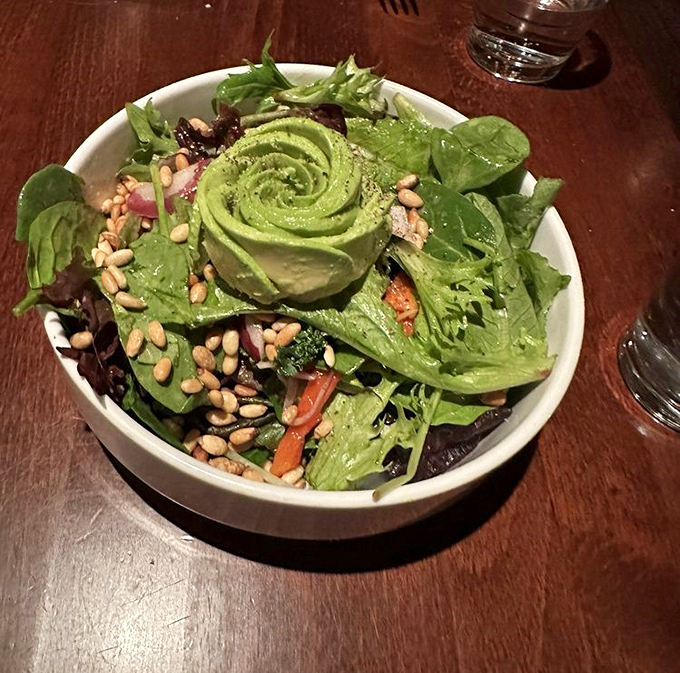 When an avocado gets the royal treatment: sculpted into a rose, surrounded by fresh greens and pine nuts. Salad as art, art as lunch.