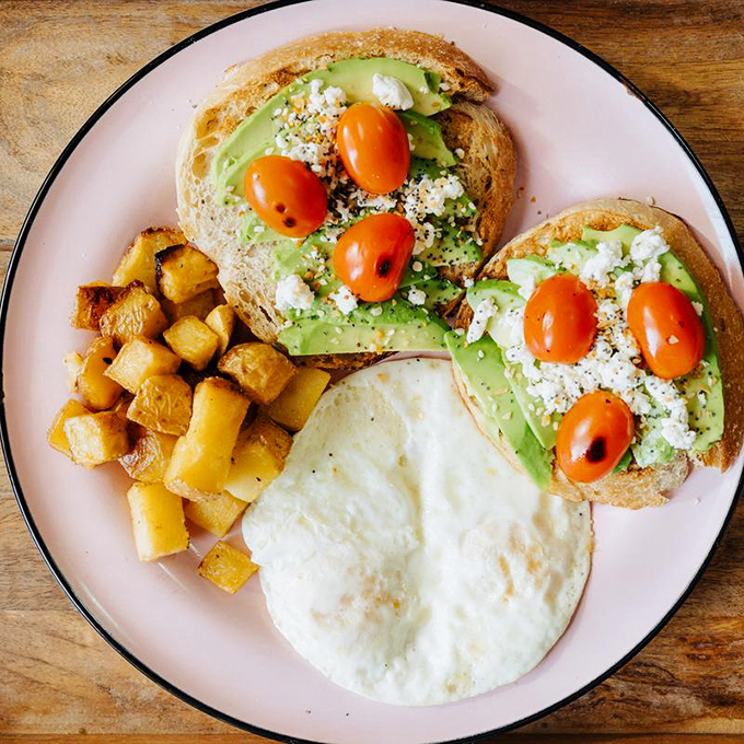 Avocado toast that Instagram was invented for&mdash;creamy avocado, bright tomatoes, and crumbled cheese on perfectly toasted bread with golden potatoes on the side.