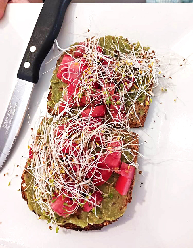 Avocado toast elevated to art form with microgreens and vibrant tomatoes. Even your most judgmental foodie friend would snap a picture before taking a bite.