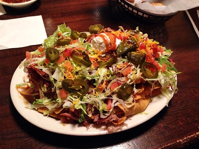 BBQ nachos that laugh in the face of convention – a mountain of chips buried under an avalanche of meat, cheese, and jalapeños.
