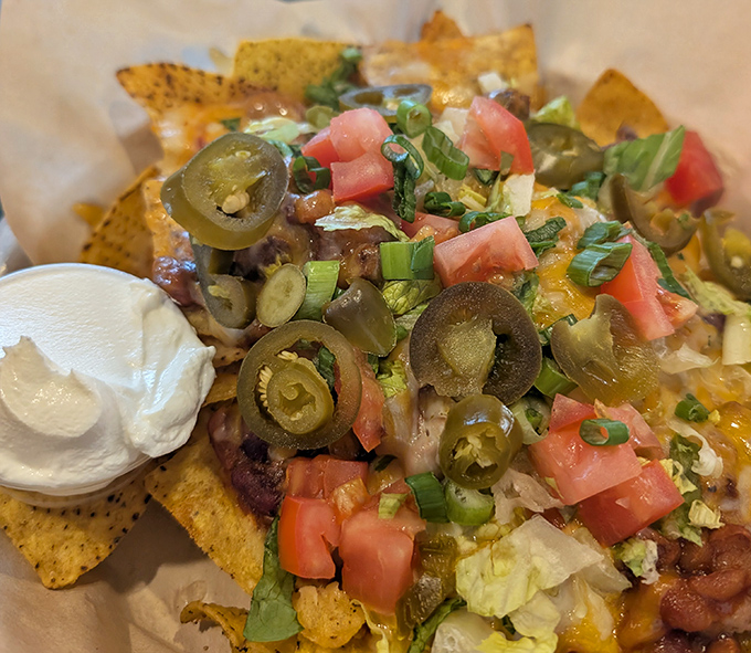 BBQ nachos that laugh in the face of subtlety—loaded with jalapeños, tomatoes, and enough toppings to make a chip disappear.