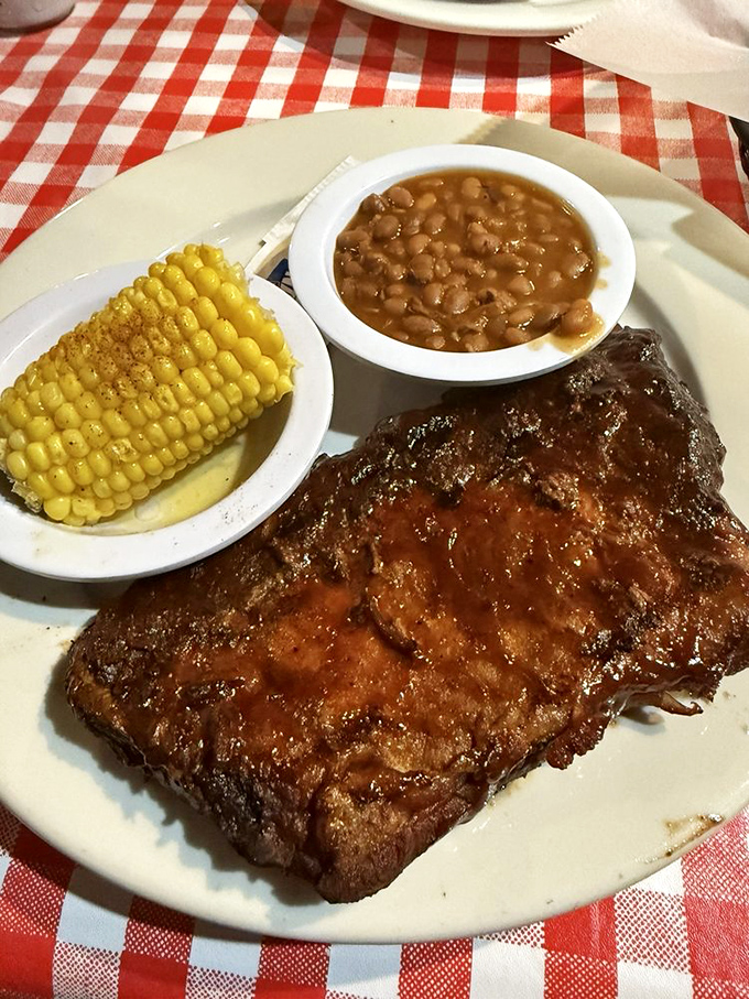 BBQ ribs so tender they practically surrender to your fork, while that corn cob stands by like a loyal sidekick to the main attraction.